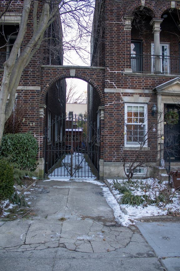 Winter Scene Featuring a Gate and a Brick Building in Brooklyn Stock ...