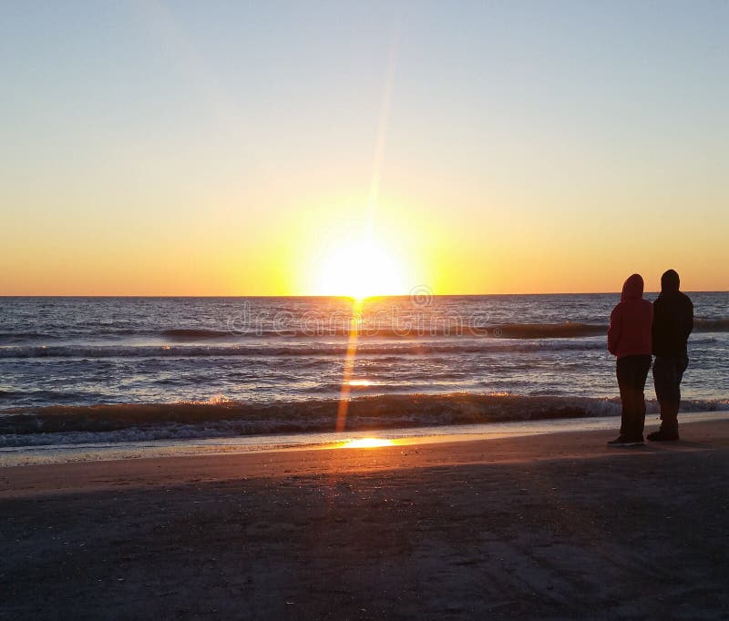 Winter Beach Sunset with Bundled-Up Couple Stock Photo - Image of ...