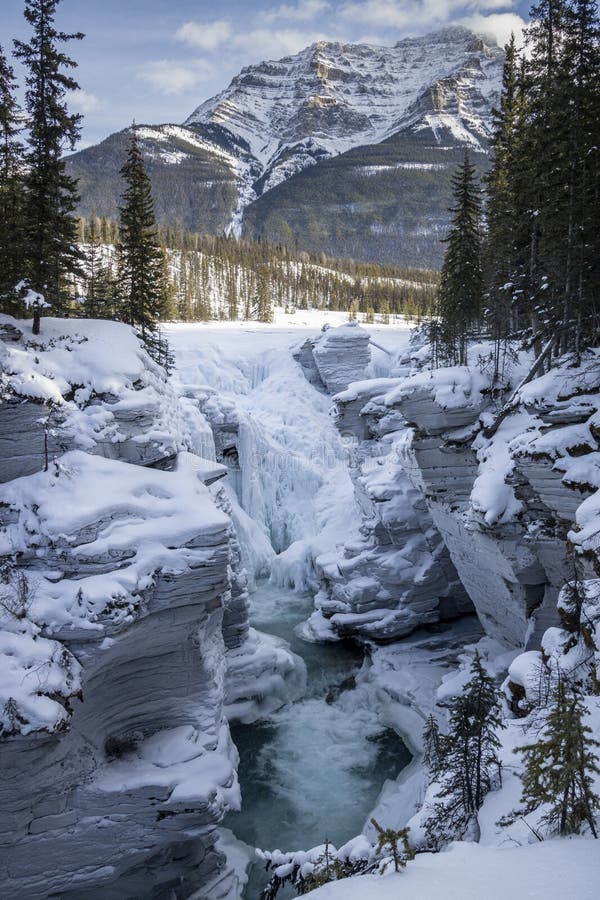 Winter Waterfall Cascading through Rocky Cliffs in the Mountains of ...