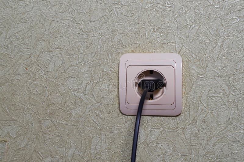 A Wire with a Plug from an Electrical Appliance is Inserted into an ...