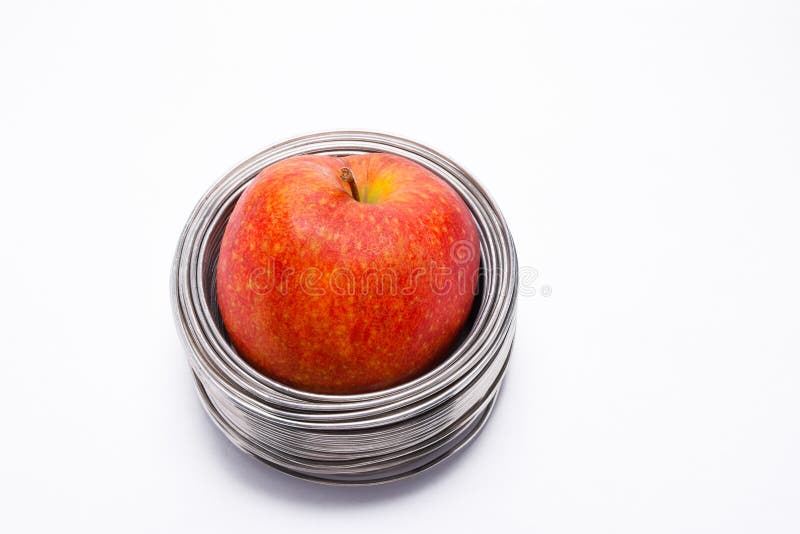 Wired Apple: Whole Red Apple in Coils of Aluminum Wire Isolated Stock ...