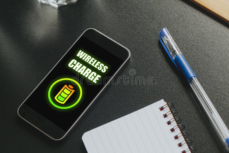 Wireless Charge in a Mobile Phone Screen Over a Black Business Table ...