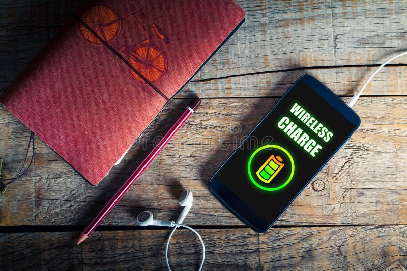 Wireless Charge in a Mobile Phone Screen Over a Wooden Table. Stock ...