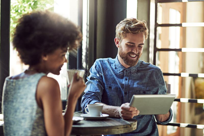 Wireless Connections. Shot of Two People Using a Digital Tablet in a ...