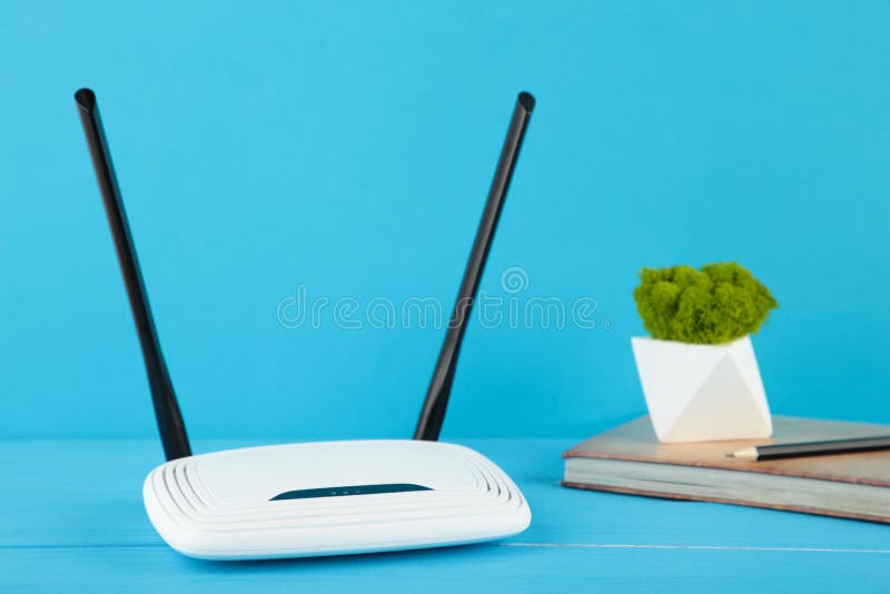 Wireless Wi-Fi Router on Blue Background with Notebook on Beige Stock ...