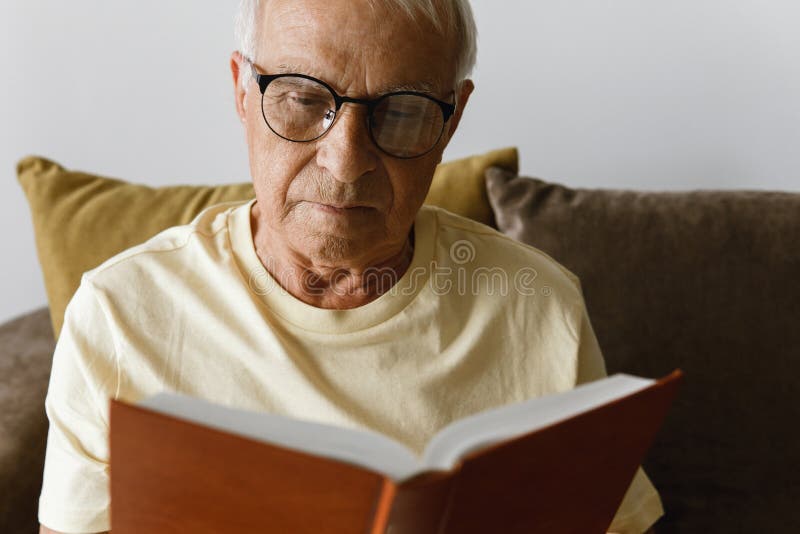 Wise and Elderly Man is Reading Book at Home Stock Photo - Image of ...