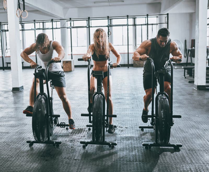 Wish less and Work More. Three People Working Out on Elliptical ...
