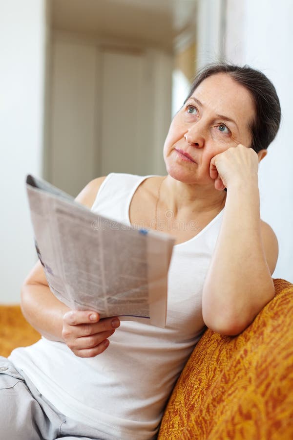 Wistful Mature Woman with Newspaper Stock Image - Image of people ...