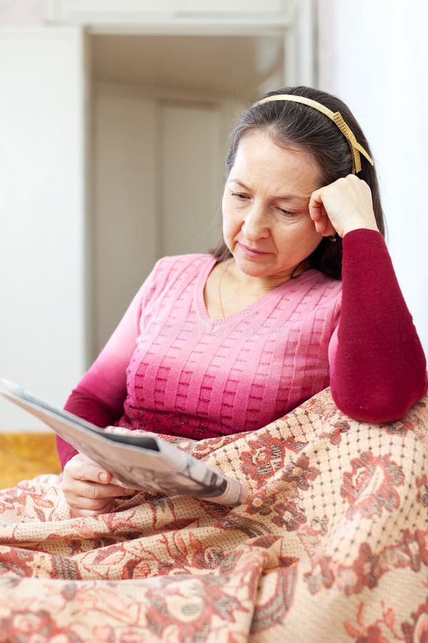 Wistful Woman Reading Newspaper Stock Image - Image of information ...