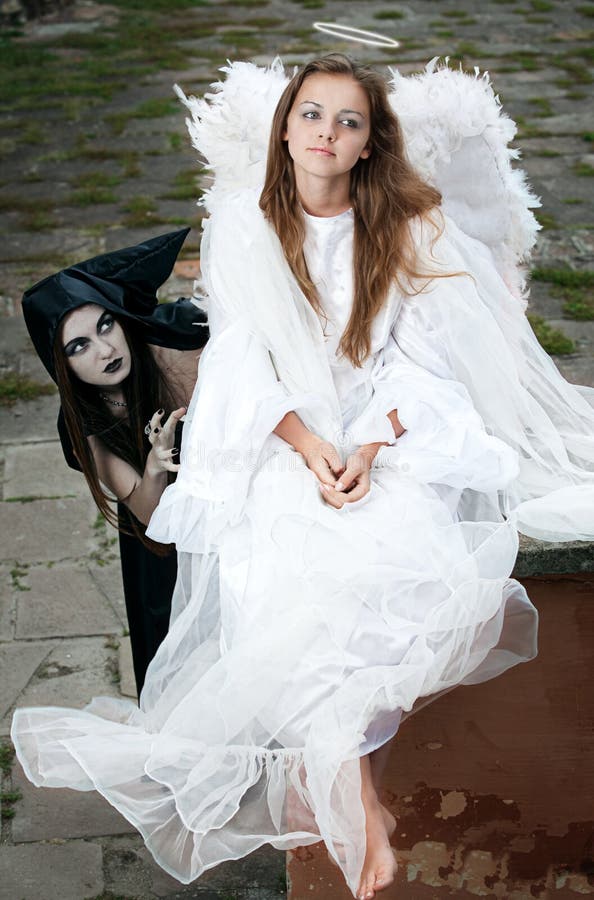 Witch and Angel Against the Walls Stock Photo - Image of calm, cruel ...