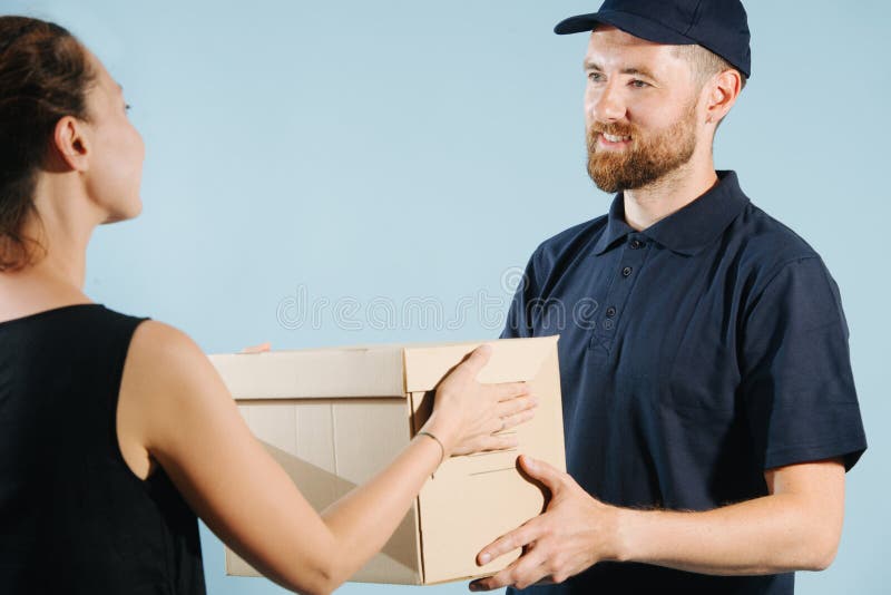 Woman is Accepting a Box Delivery from a Courier, Taking it from Him ...