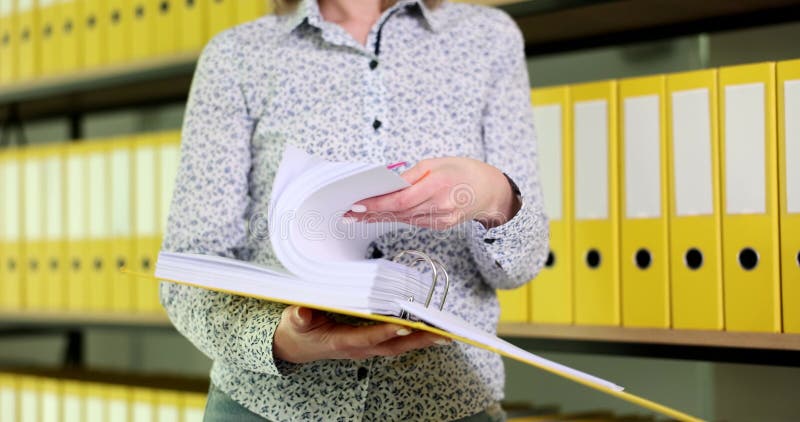 Woman Accountant Manager Leafing through Documents in a Yellow Folder ...