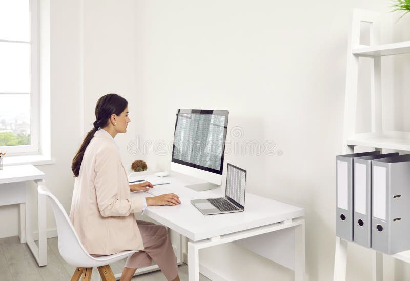 Woman Accountant Working with Spreadsheets on Computers in a Modern ...