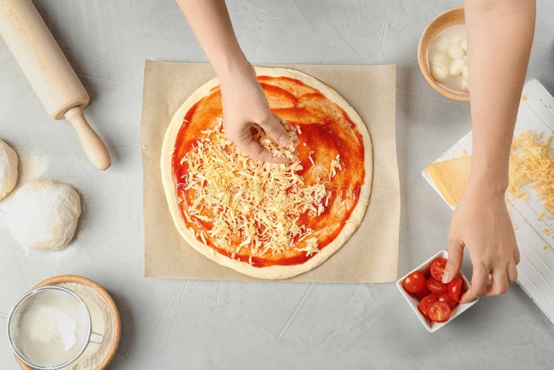 Woman Adding Grated Cheese To Pizza on Table, Top View Stock Photo ...