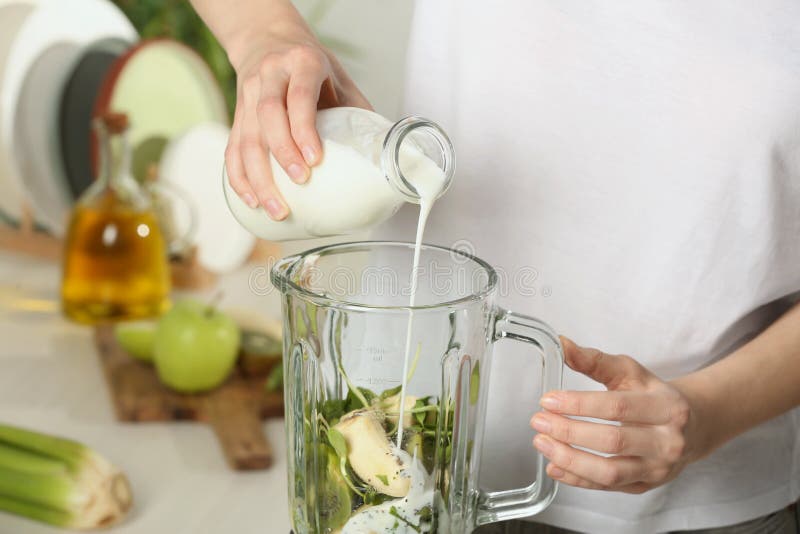 Woman Adding Milk into Blender with Ingredients for Green Smoothie ...