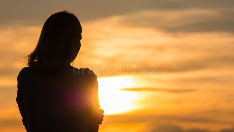 A Woman Admires a Beautiful Sunset, the View from Behind Stock Photo ...