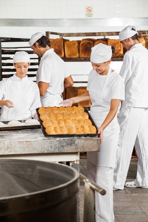 Woman Analyzing Breads while Colleagues Working in Bakery Stock Image ...