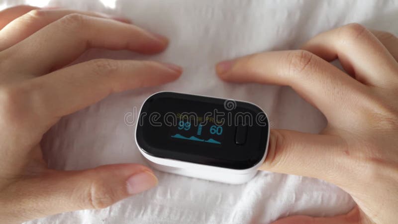 Woman Analyzing Heartbeat and Checking Oxygen Saturation at Home. Stock ...