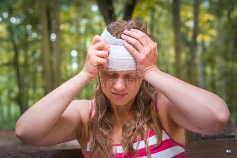 Woman Applying Bandage on Her Head after Injury in Nature Stock Photo ...