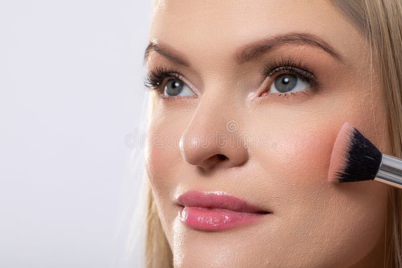A Woman Applying Blush in an Engaging Makeup Session, Excelling in ...
