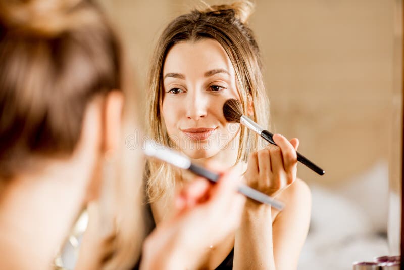Woman applying cosmetics stock image. Image of mirror - 106169137