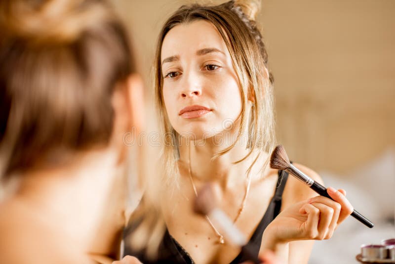 Woman applying cosmetics stock photo. Image of indoors - 106169154