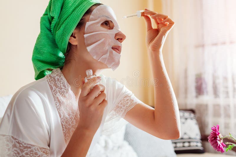 Woman Applying Facial Hyaluronic Acid Serum Wearing Sheet Mask