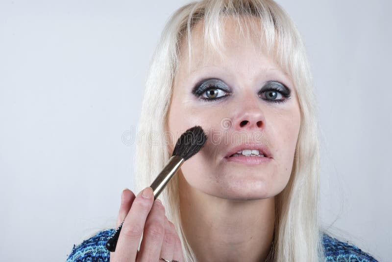 Woman applying makeup stock image. Image of product - 181742623