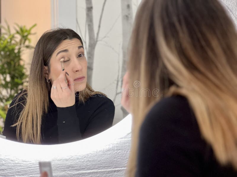 Woman Applying Makeup in Front of a Mirror Stock Image - Image of ...