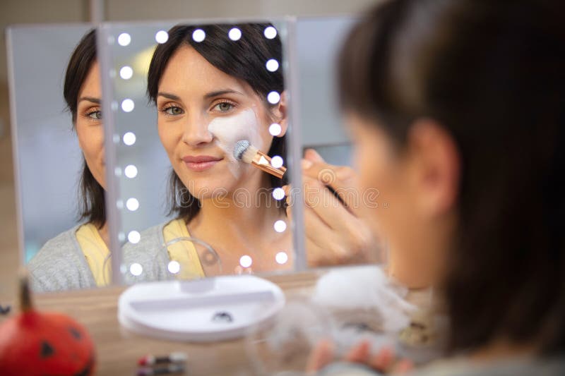 Woman Applying White Face Paint Looking in Mirror Stock Image - Image ...