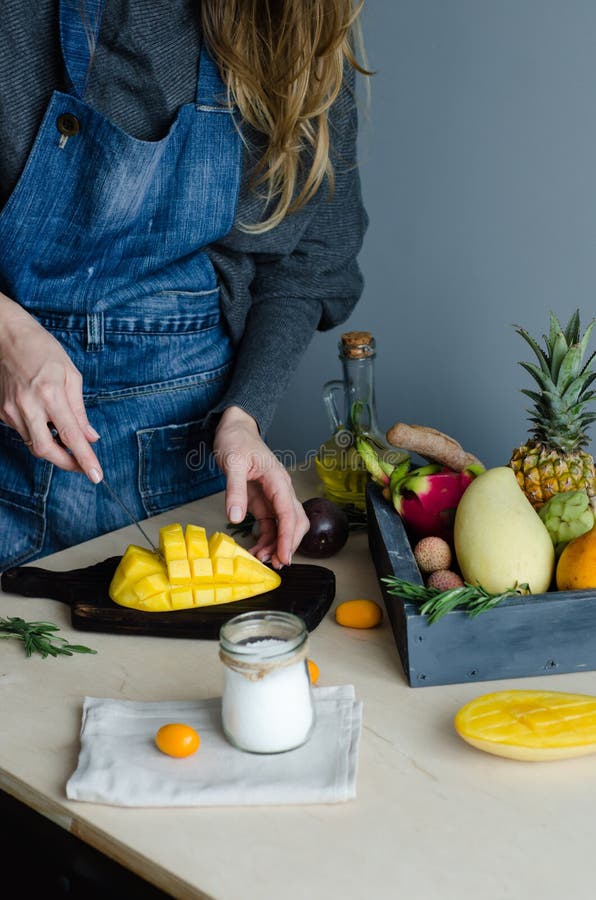 Woman in Apron Cuts Fruit while Standing at the Table Stock Image ...