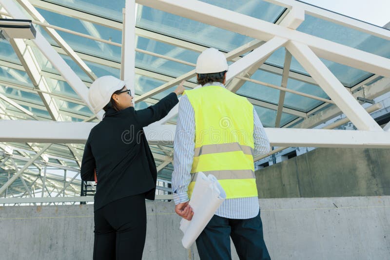 Woman Architect and Man Builder at Construction Site, Back View ...