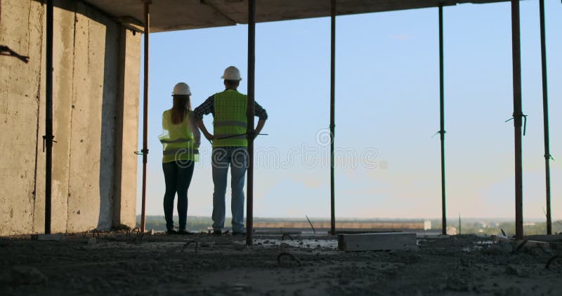 Woman Architect and Man Builder at Construction Site, Back View ...