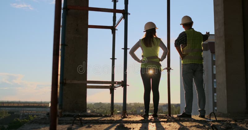 Woman Architect and Man Builder at Construction Site, Back View ...
