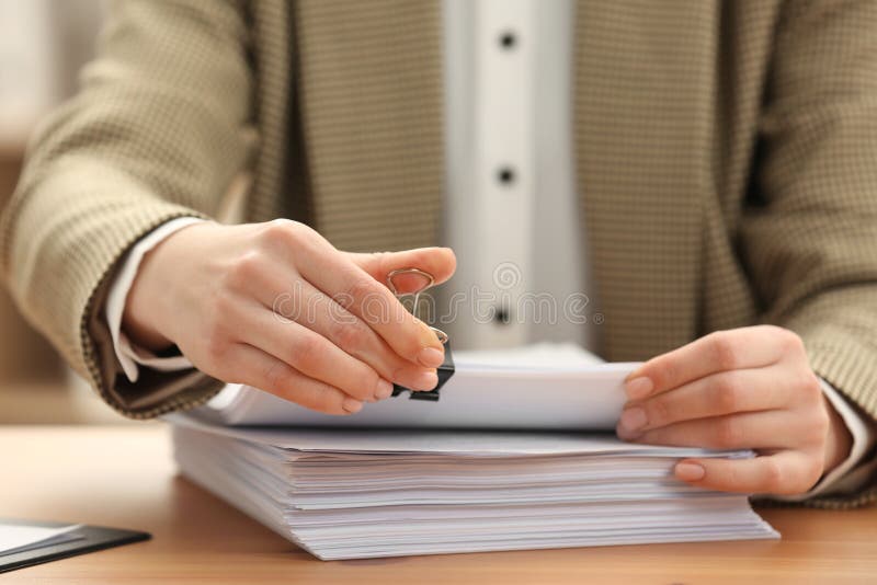 Woman Attaching Documents with Metal Binder Clip at Table in Office ...