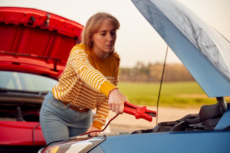 Woman Attaching Jumper Cable To Start Car Engine with Flat Battery ...