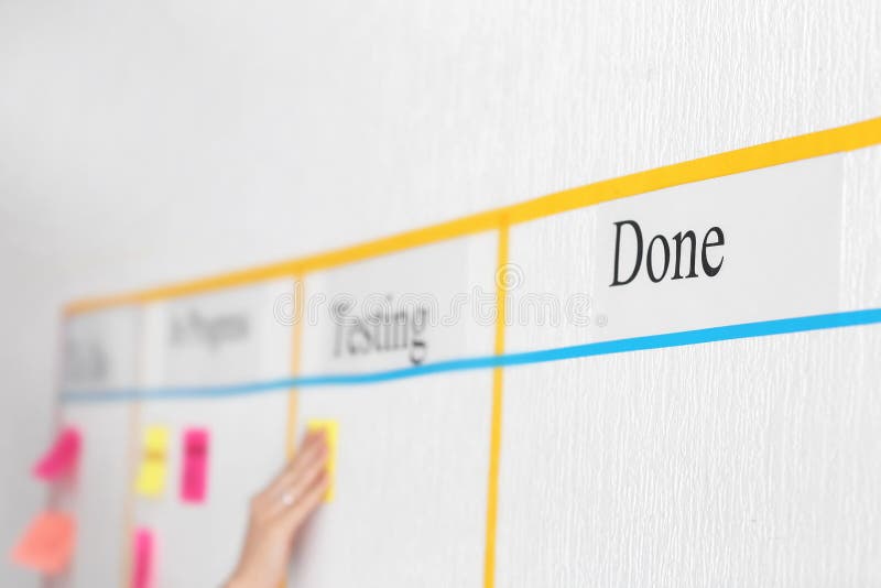 Man Attaching Sticky Note To Scrum Task Board in Office Stock Photo ...