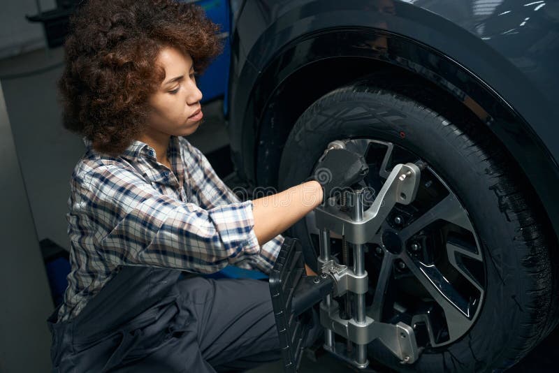 Woman Auto Mechanic Performs Wheel Balancing, Adjusts Wheel Alignment ...