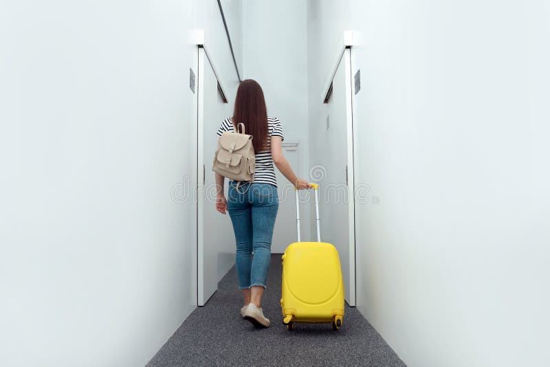 Woman with Backpack and Suitcase Walking Along Hostel Corridor, Back ...
