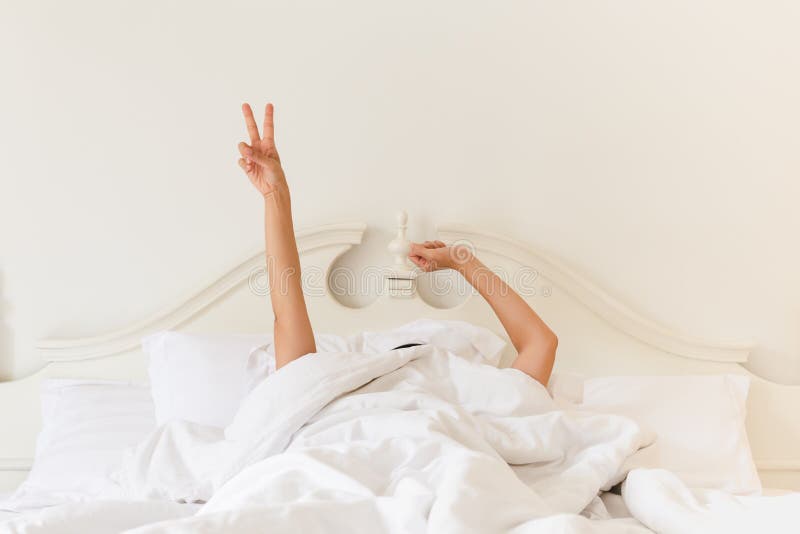Woman In Bed Under The Blanket Stretching Hand After Waking Up Stock