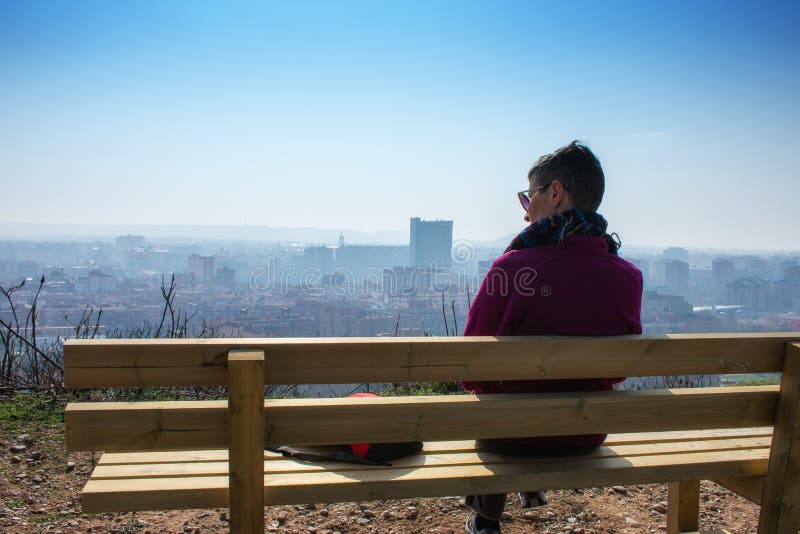 Woman from Behind Sitting on Bench with City in Background Stock Image ...