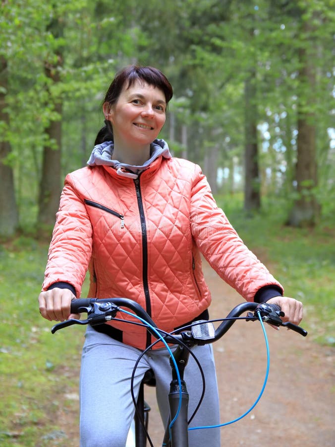 Woman on a bicycle stock photo. Image of cyclist, green - 184526632