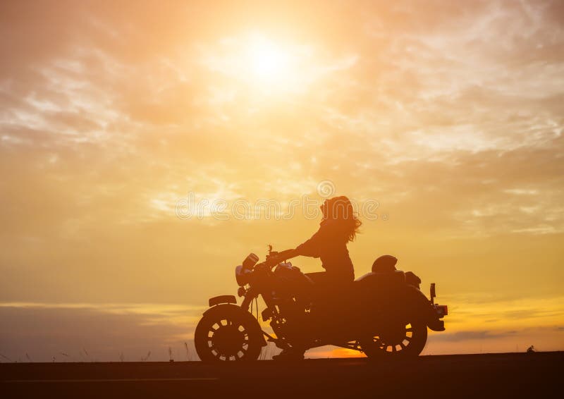 Woman biker over sunset stock photo. Image of motorcycle - 152563556