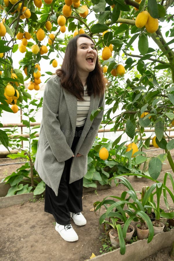 Woman Biting Lemon in Lemon Garden. Stock Image - Image of reaction ...