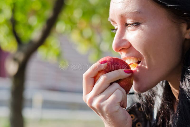 Woman Biting into a Red Apple Stock Photo - Image of brunette ...