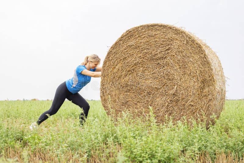 Woman Exercising with Hay Bale in Field Stock Photo - Image of training ...