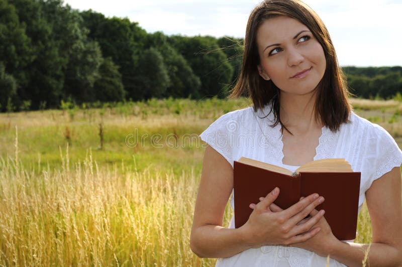 Woman with book in field stock image. Image of quizzical - 15477859