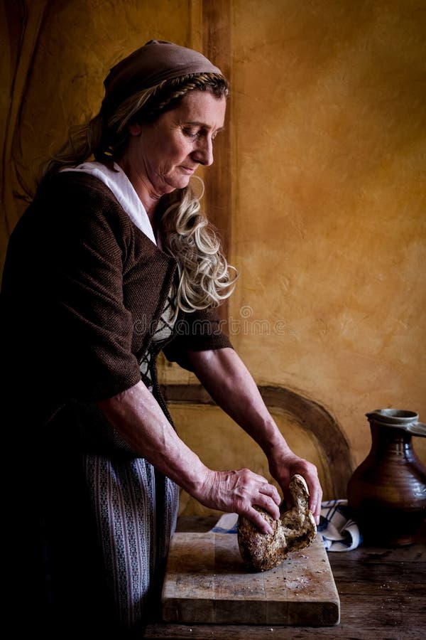 Woman breaking the bread stock photo. Image of costume - 252795498
