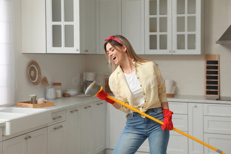 Woman with Broom Singing while Cleaning in Kitchen Stock Photo - Image ...