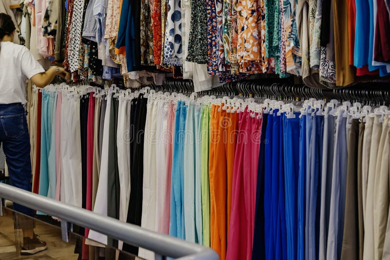 Woman Browsing Colorful Samples of Clothes Hanging in Store Stock Photo ...